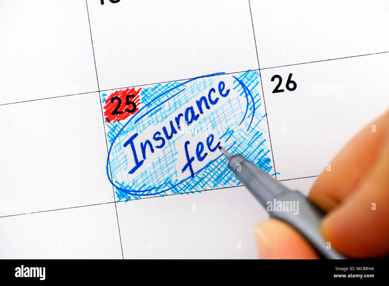 Woman fingers with pen writing reminder Insurance Fee in calendar ...