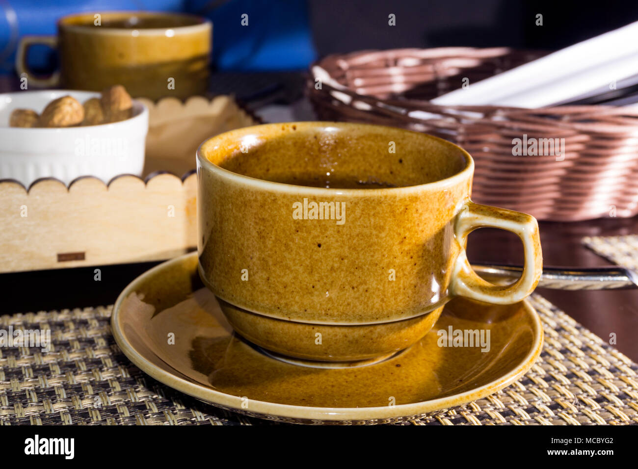 cup in yellow spotted glaze with green tea closeup on blurred ...