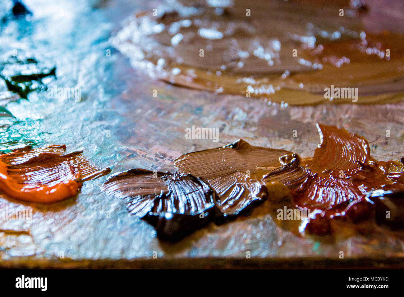 Used artist's palette with mixed colors of acrylic paints closeup as ...