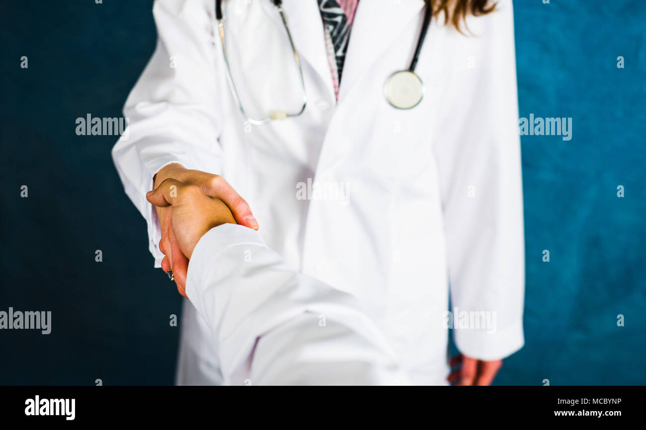 Two doctors shaking hands close up, Team work Stock Photo - Alamy