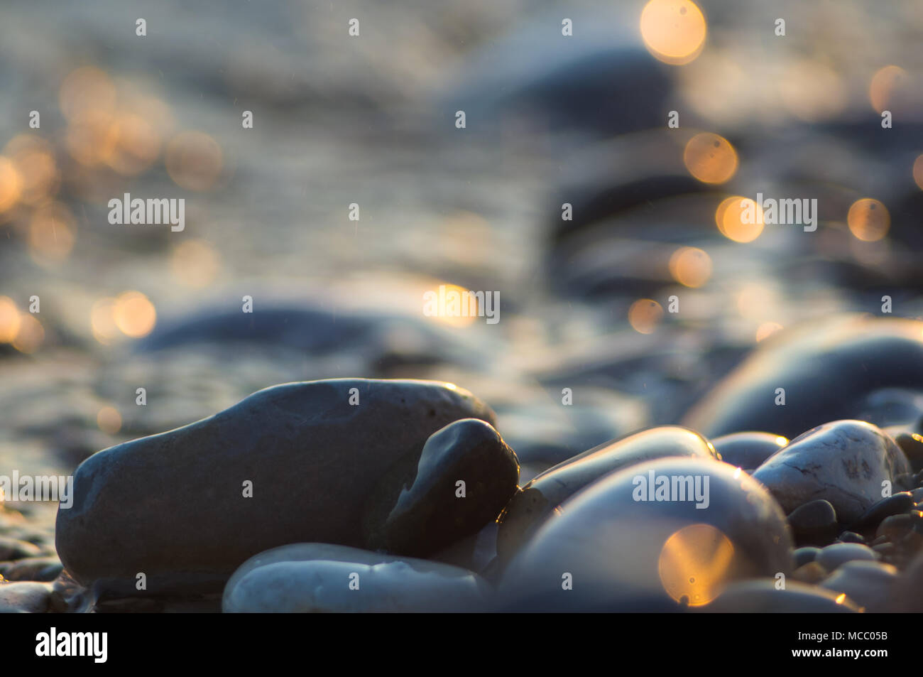 pebble stones on the sea beach on a warm summer day, the rolling waves ...