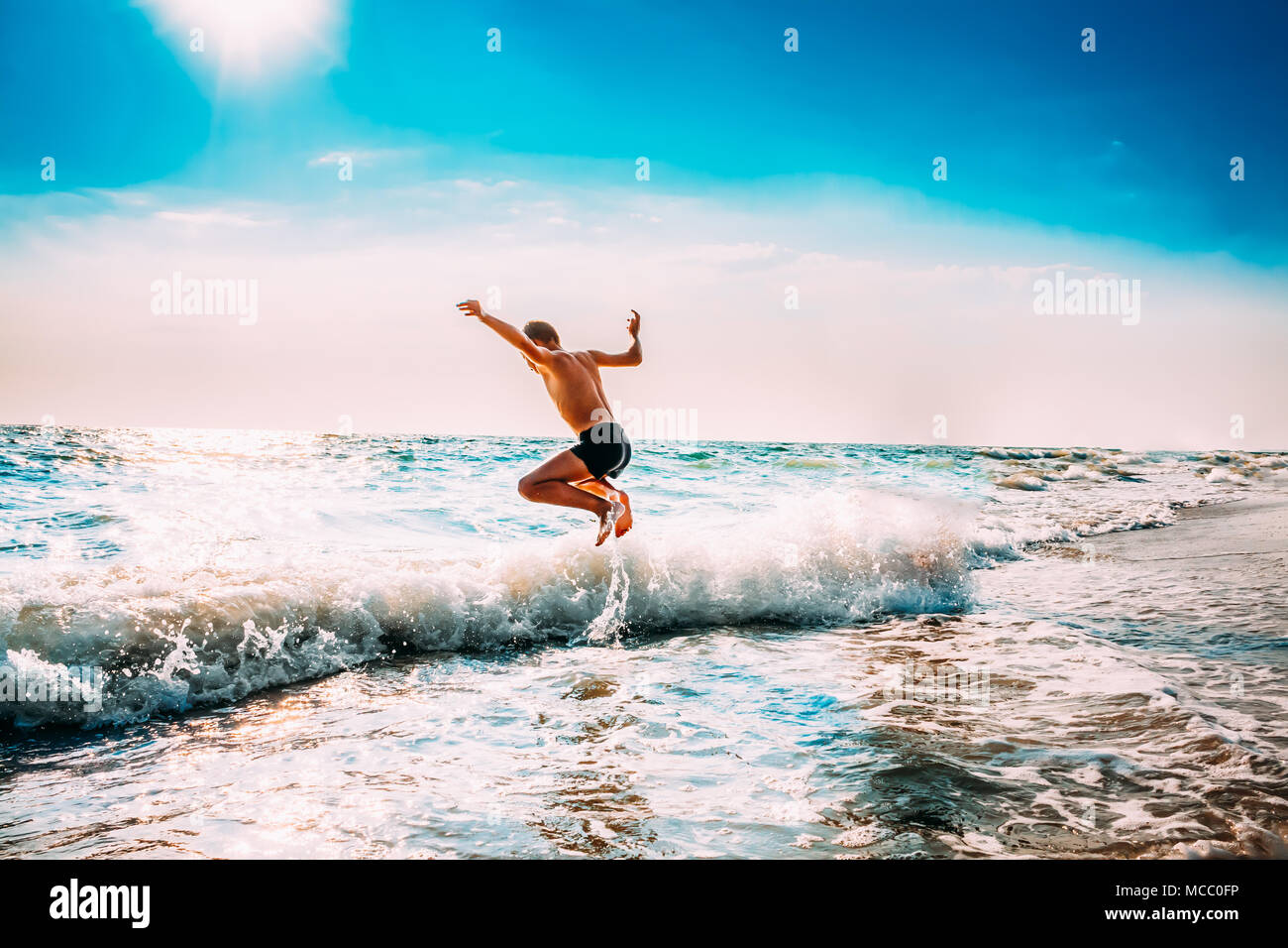 Happy boy jumping in waves hi-res stock photography and images - Alamy