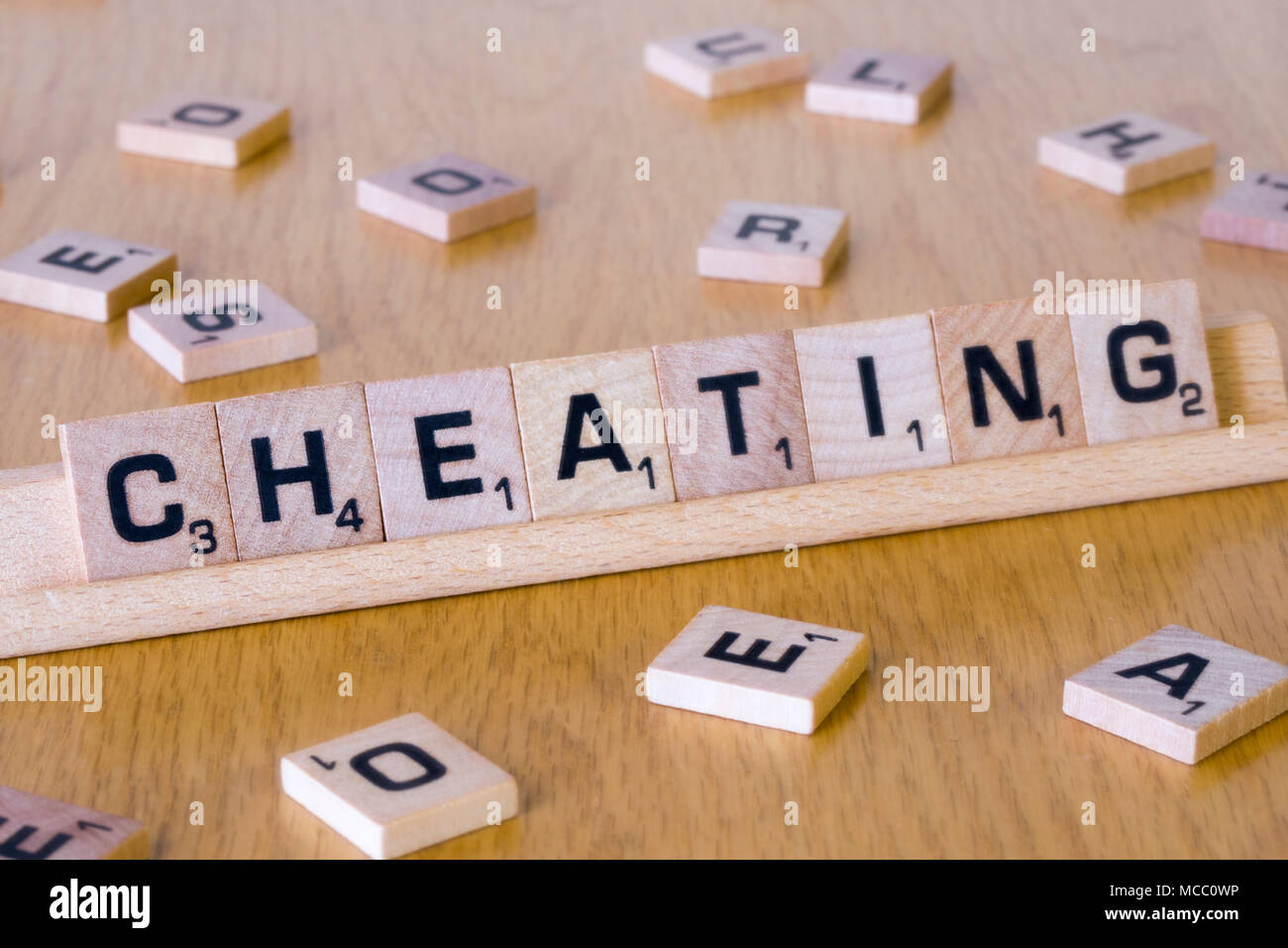 Scrabble letters spelling out the word Cheating Stock Photo - Alamy