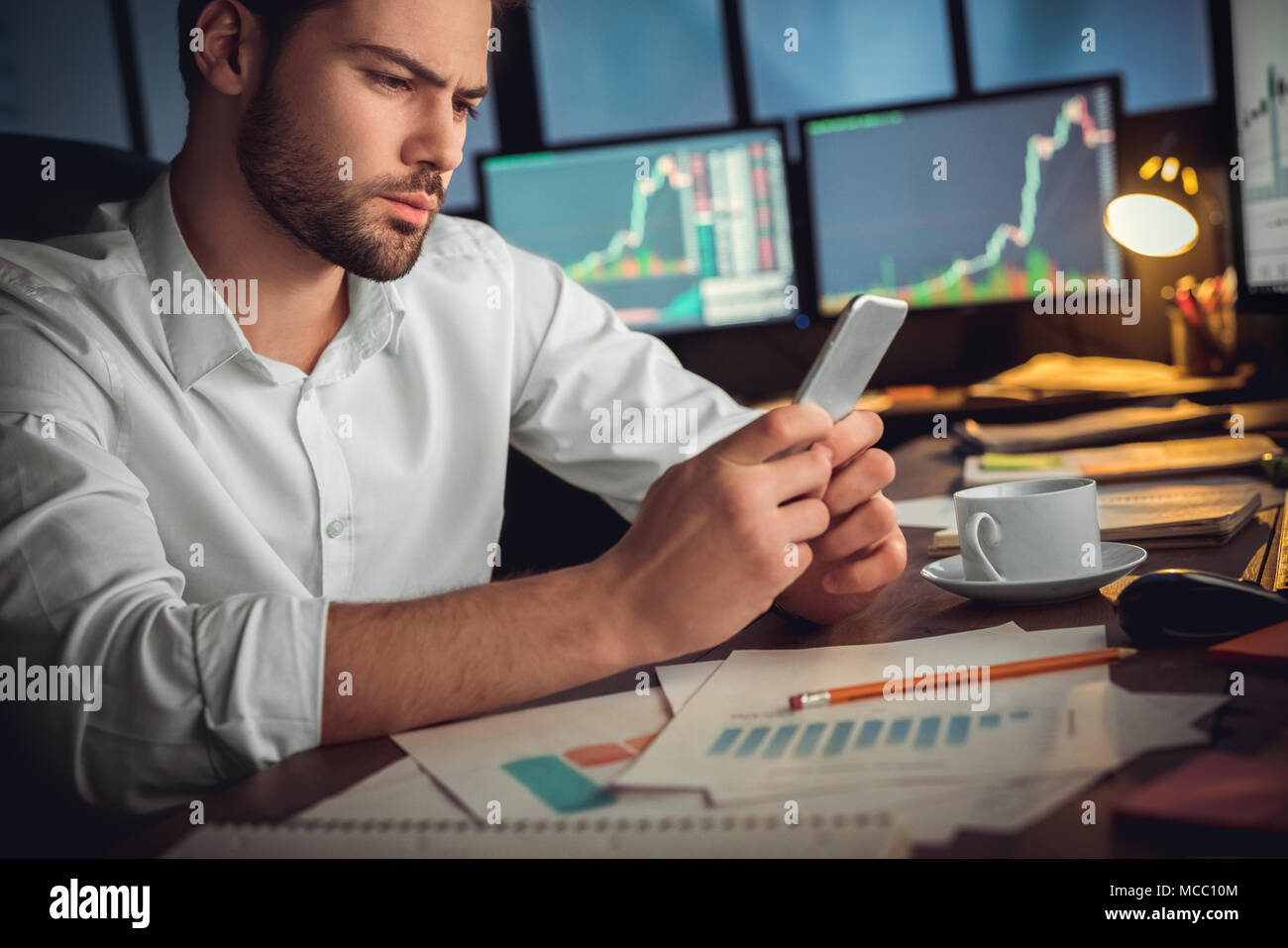 Serious trader using mobile phone app on smartphone for checking stock ...