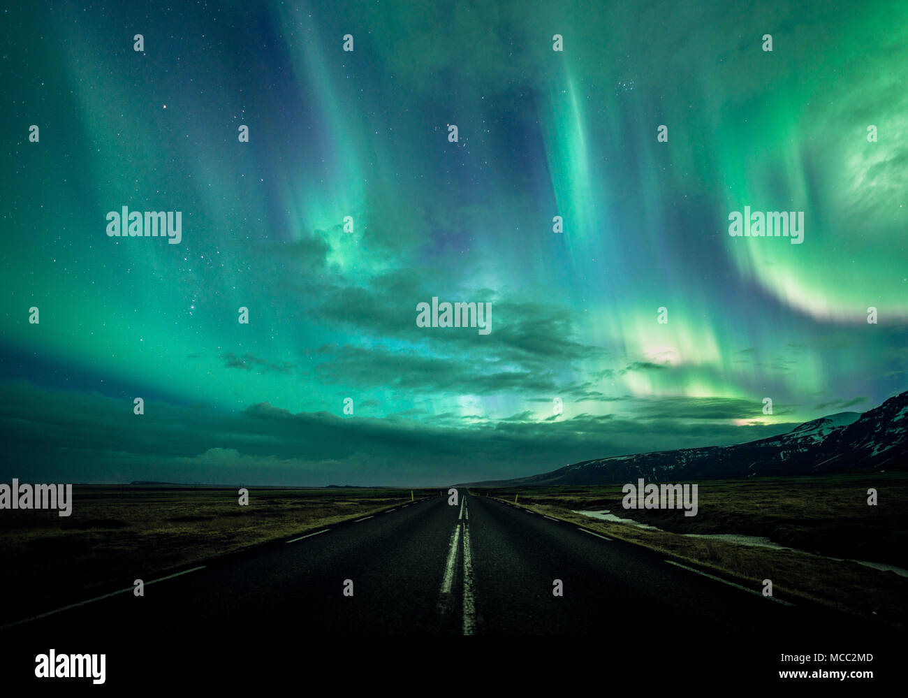 Night scene of a road leading towards distance with Northern lights aka ...