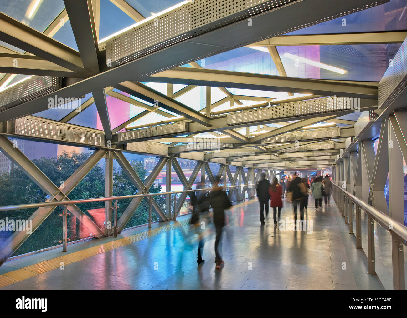 Night scenery with illuminated pedestrian bridge in commercial area ...