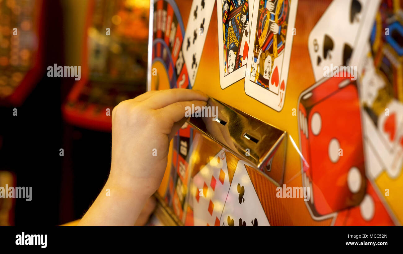 Close-up Of Childs Hands Inserting Coin Into Slots Machine Stock Photo ...