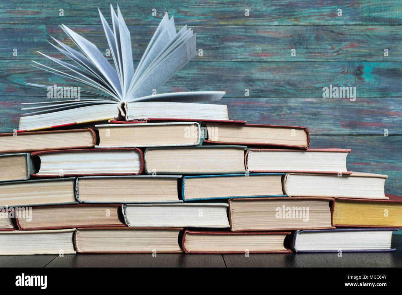 Open book hardback on Stack books Stock Photo - Alamy