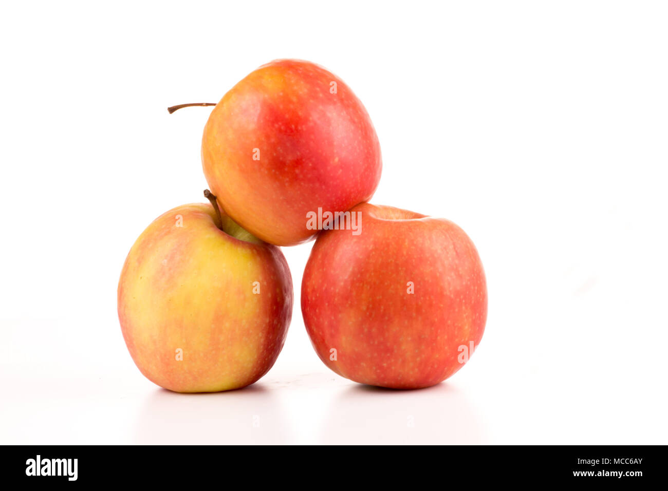 three red-orange apples stacked Stock Photo - Alamy