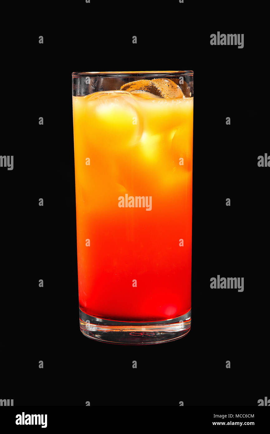 A multicolored, two-layered opaque cocktail in a tall glass with ice ...