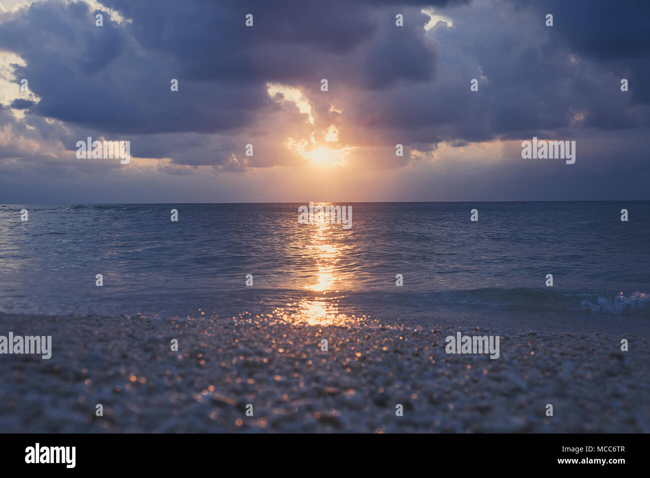 Evening sunset on the sea,. purple cloud in orange sky. small sun look ...