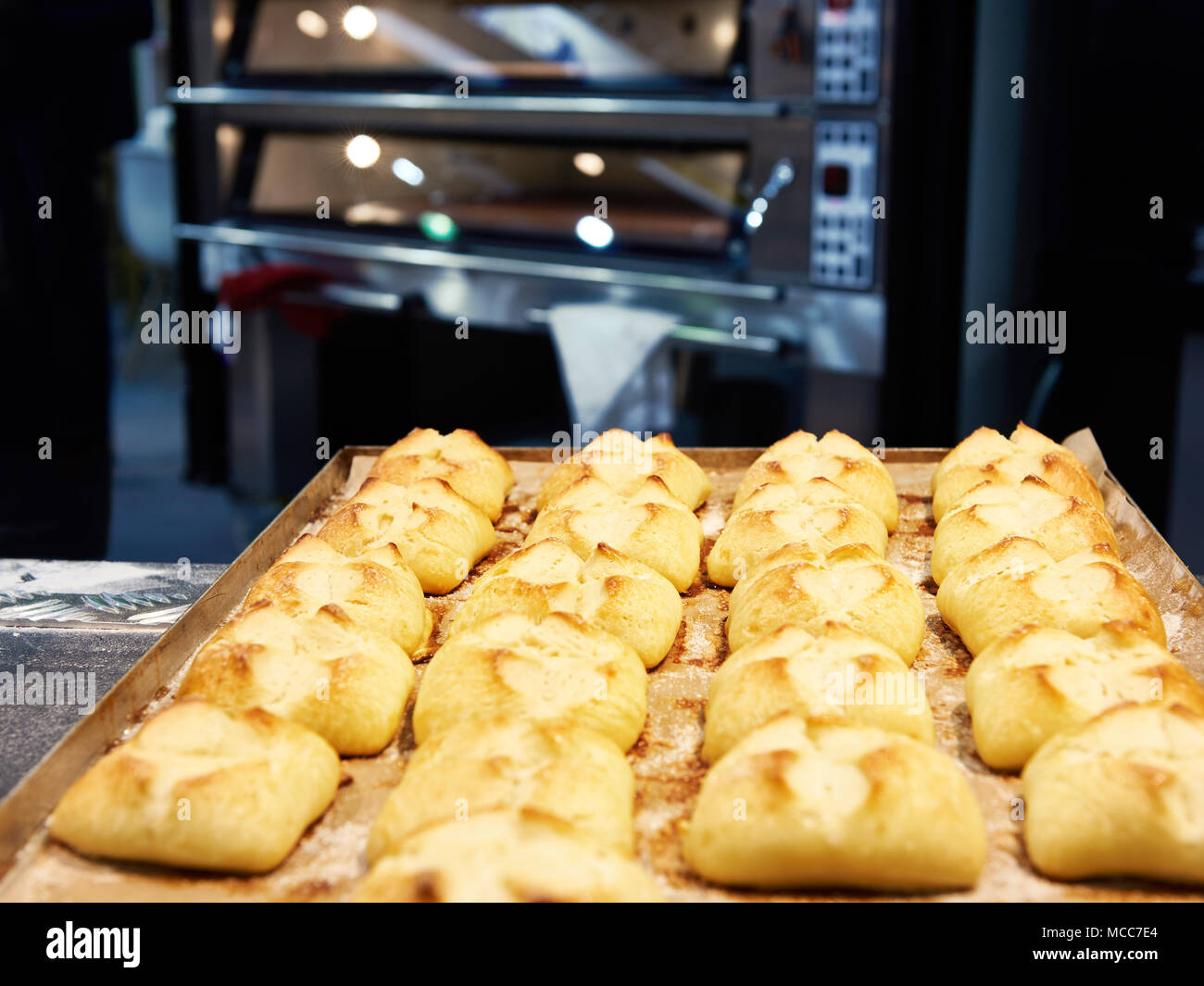 Freshly baked buns on a baking sheet and oven Stock Photo - Alamy