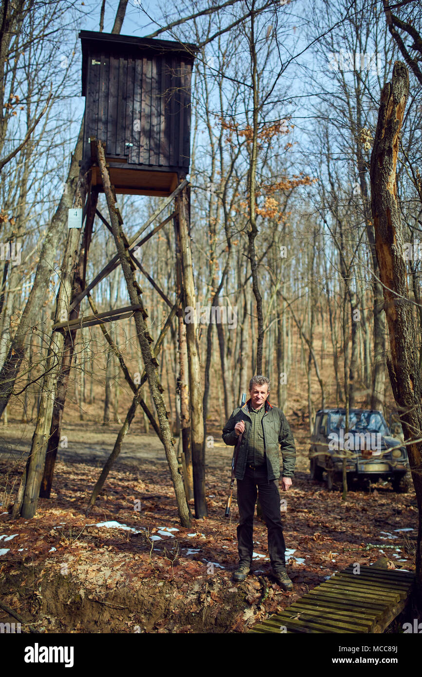 Game ranger with gun at the feeding spot for wild animals Stock Photo ...