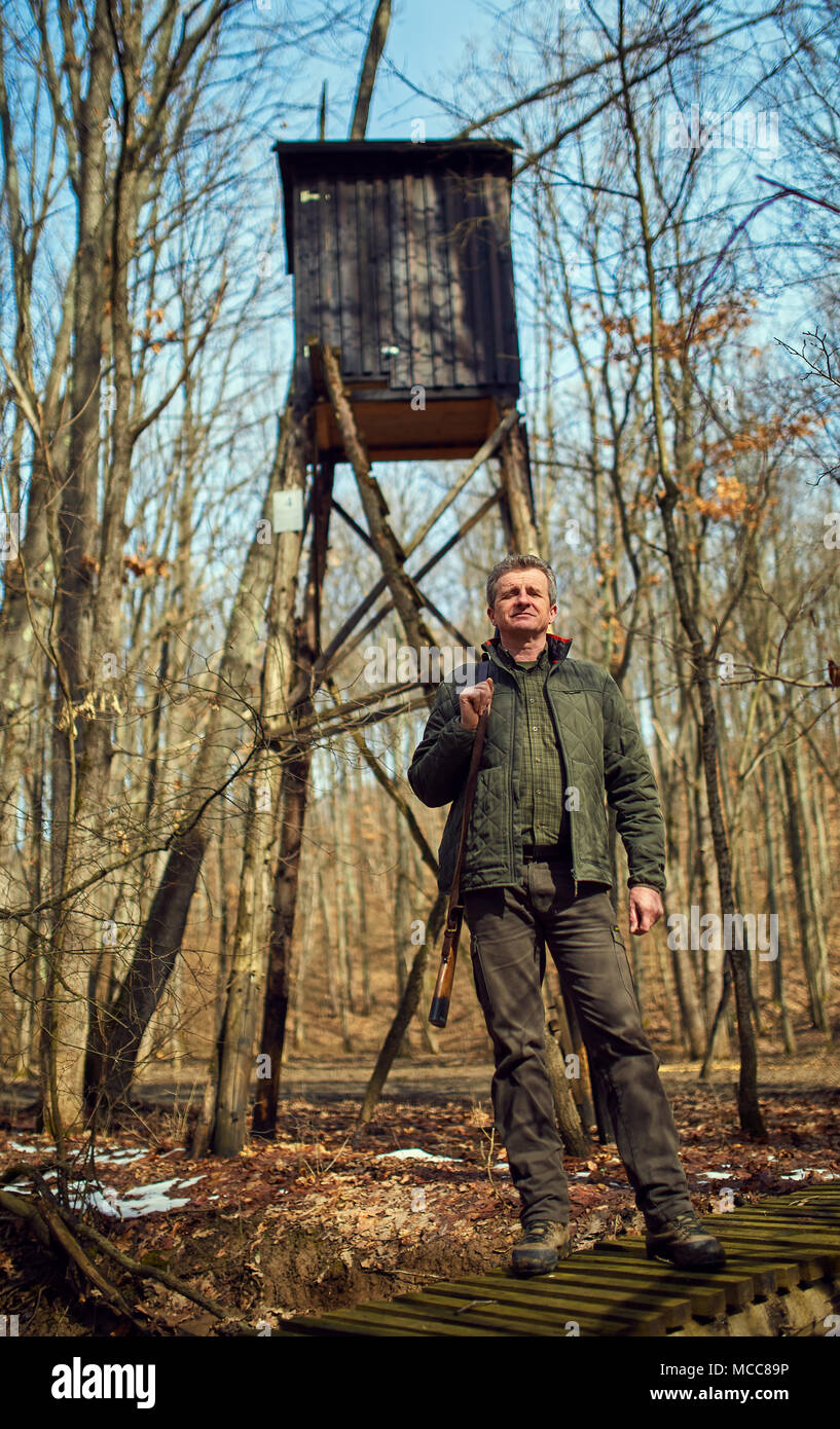 Game ranger with gun at the feeding spot for wild animals Stock Photo ...