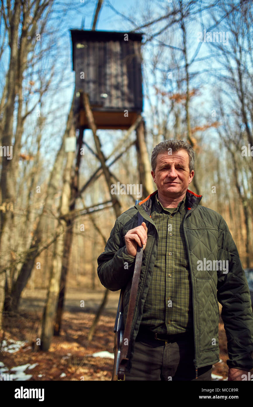 Game ranger with gun at the feeding spot for wild animals Stock Photo ...