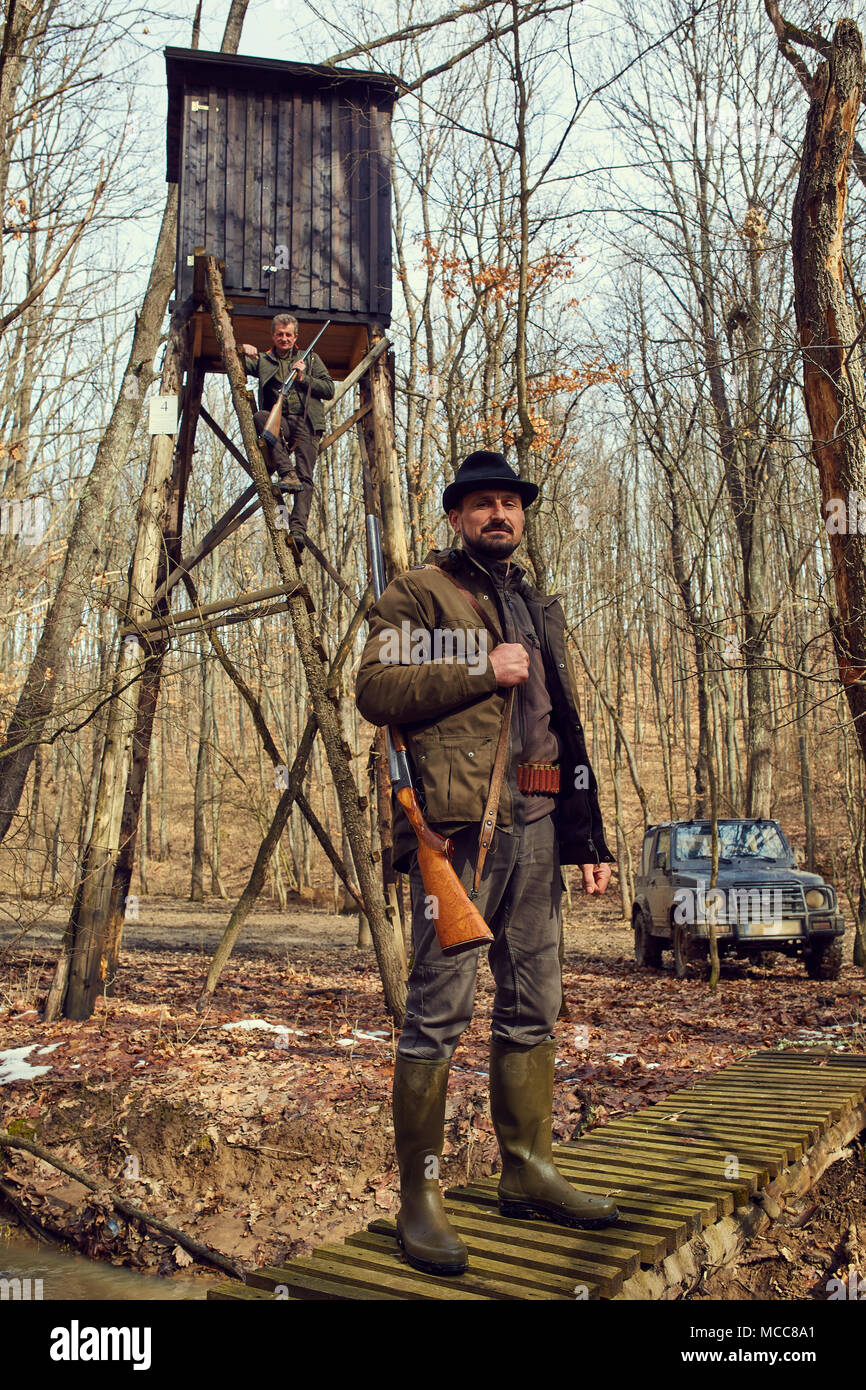 Game ranger with gun at the feeding spot for wild animals Stock Photo ...