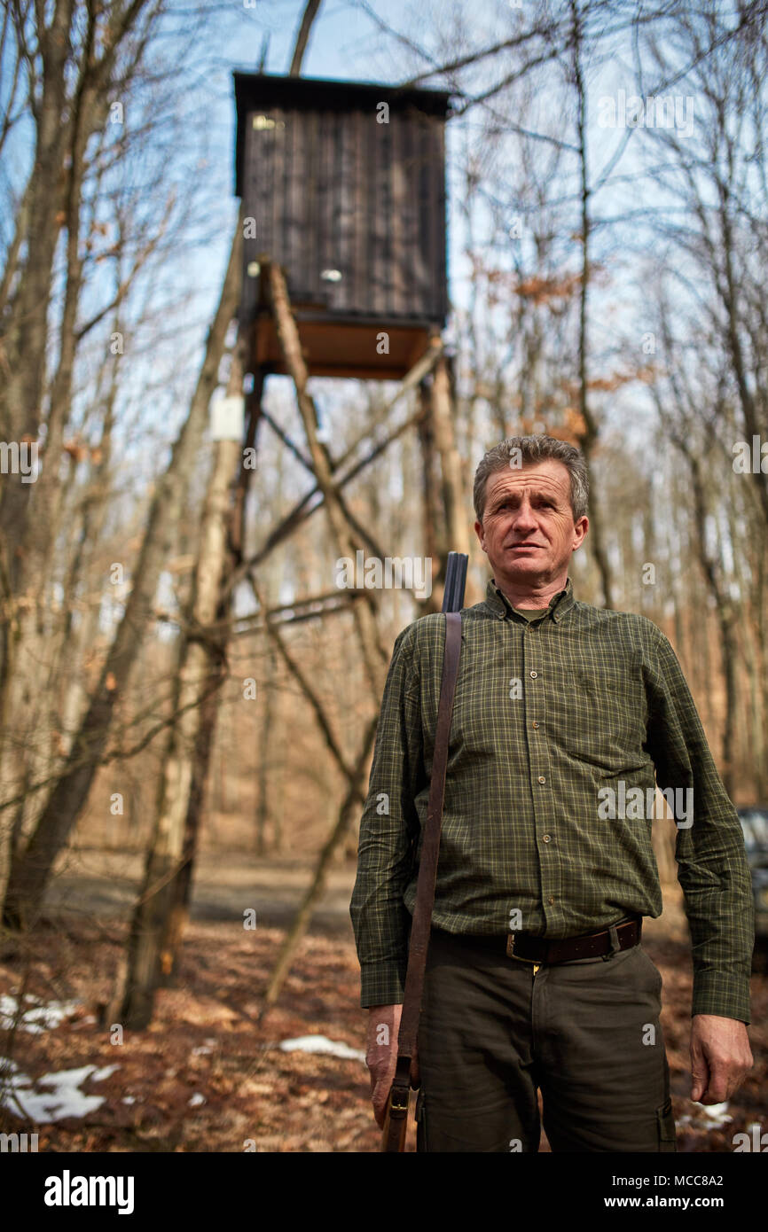 Game ranger with gun at the feeding spot for wild animals Stock Photo ...