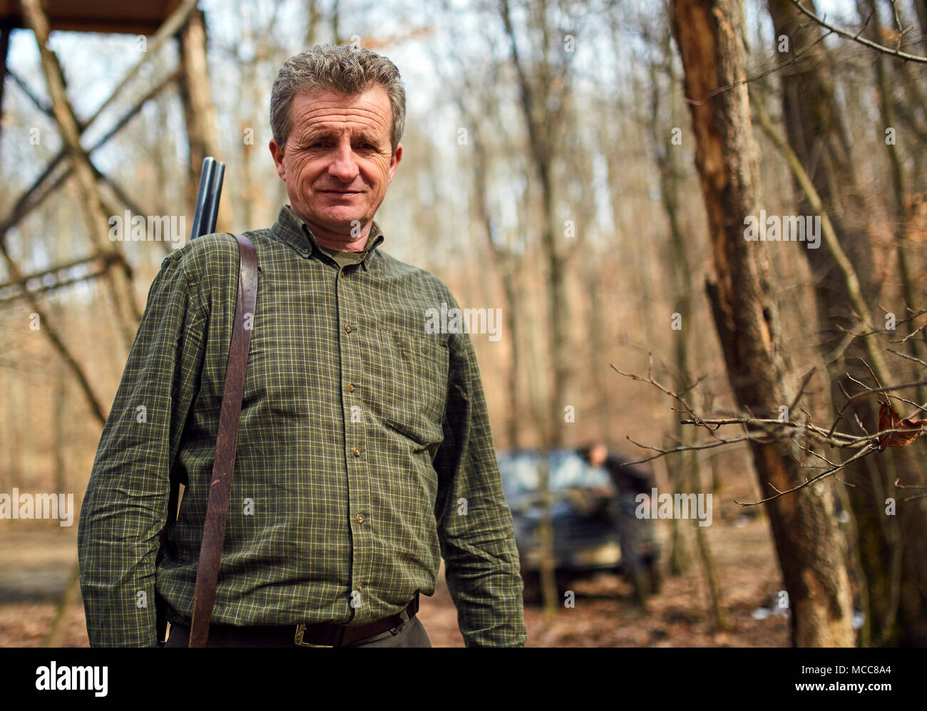 Game ranger with gun at the feeding spot for wild animals Stock Photo ...