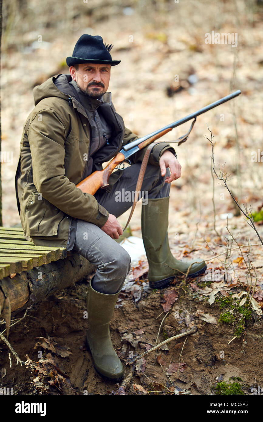 Game ranger with gun at the feeding spot for wild animals Stock Photo ...