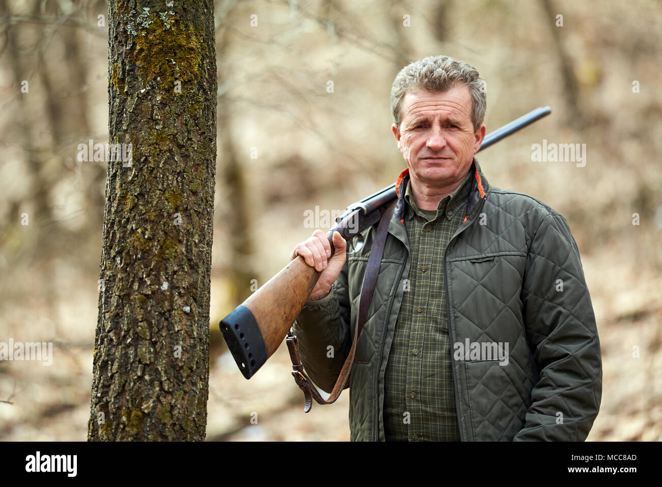Game ranger with gun at the feeding spot for wild animals Stock Photo ...