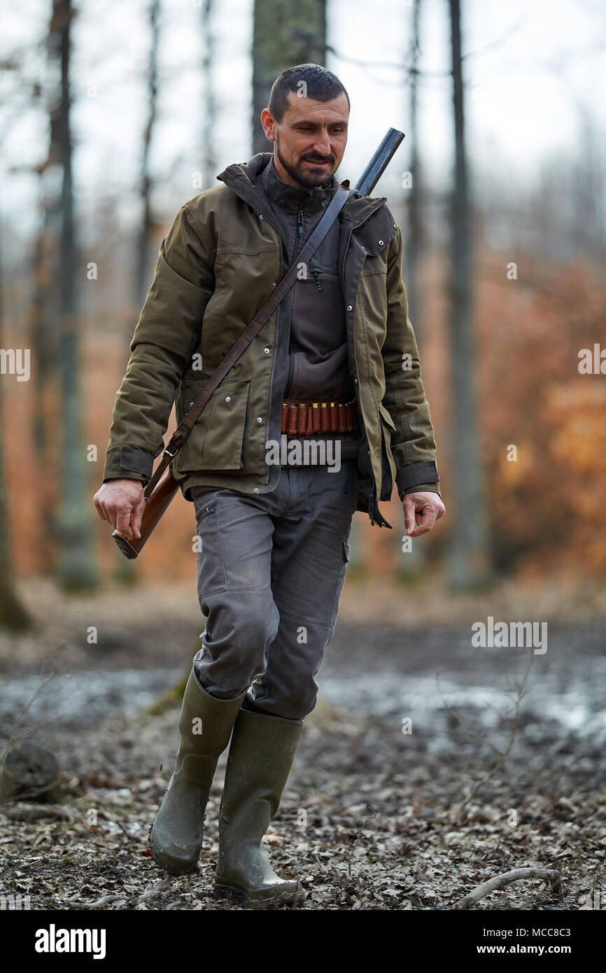 Game ranger with gun at the feeding spot for wild animals Stock Photo ...