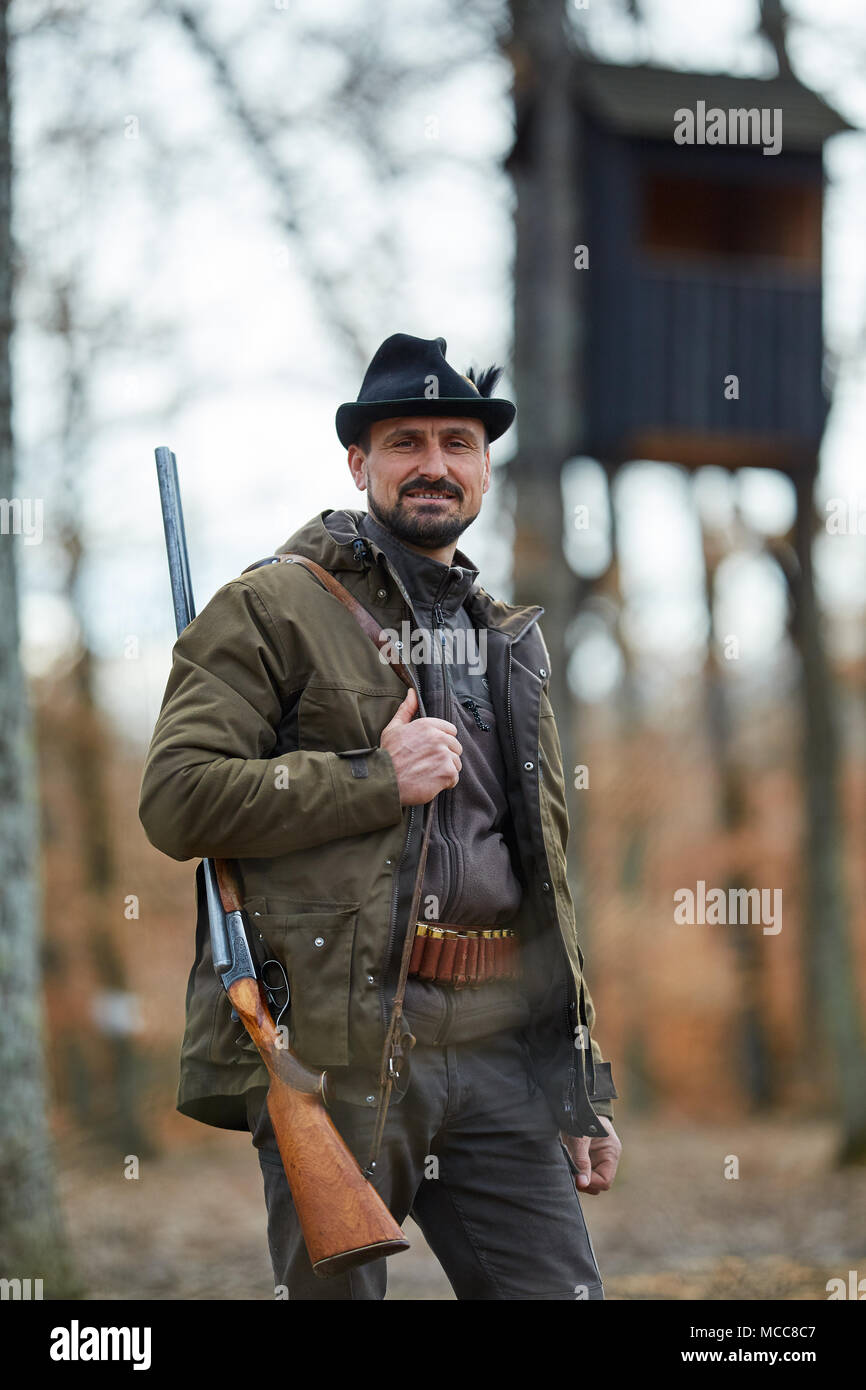 Game ranger with gun at the feeding spot for wild animals Stock Photo ...