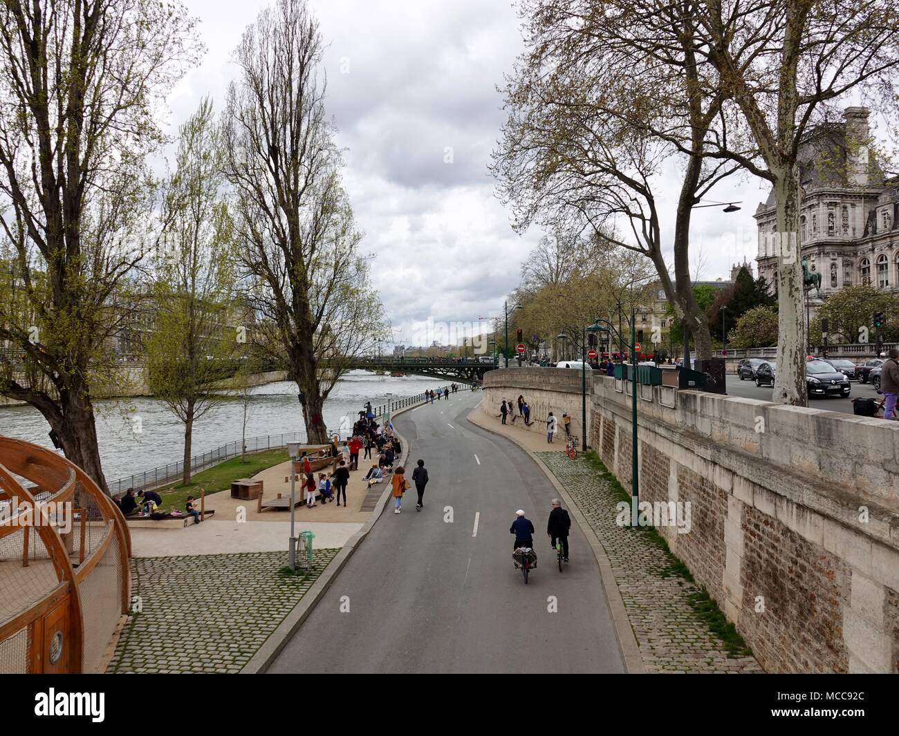 People bike, stroll, and picnic along the Seine River on a Sunday ...