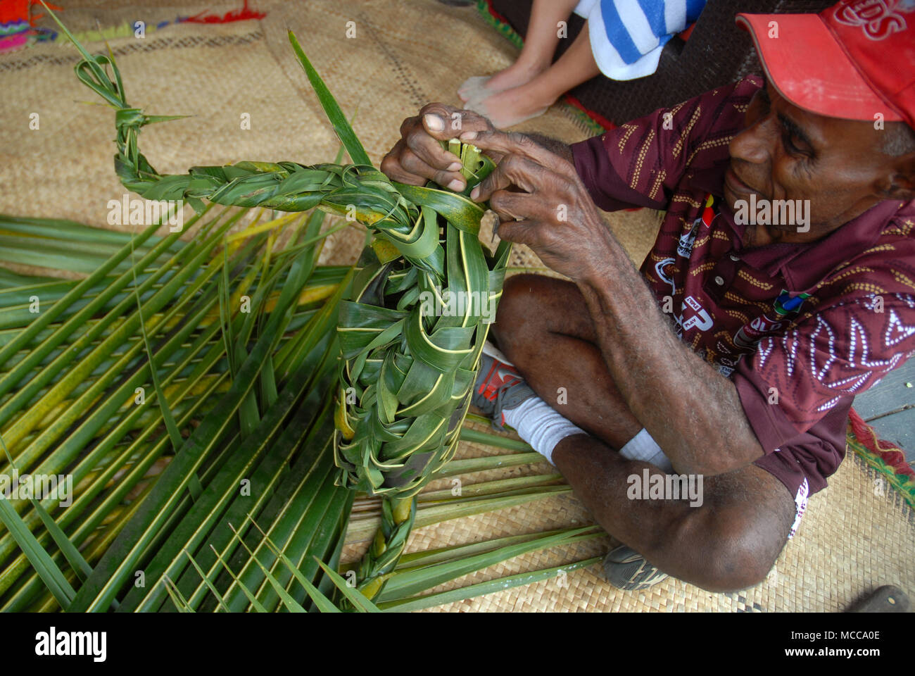 Fijian man creates a basket from weaving a Coconut Palm leaves, Pacific ...