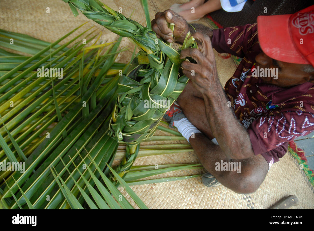 Fijian man creates a basket from weaving a Coconut Palm leaves, Pacific ...