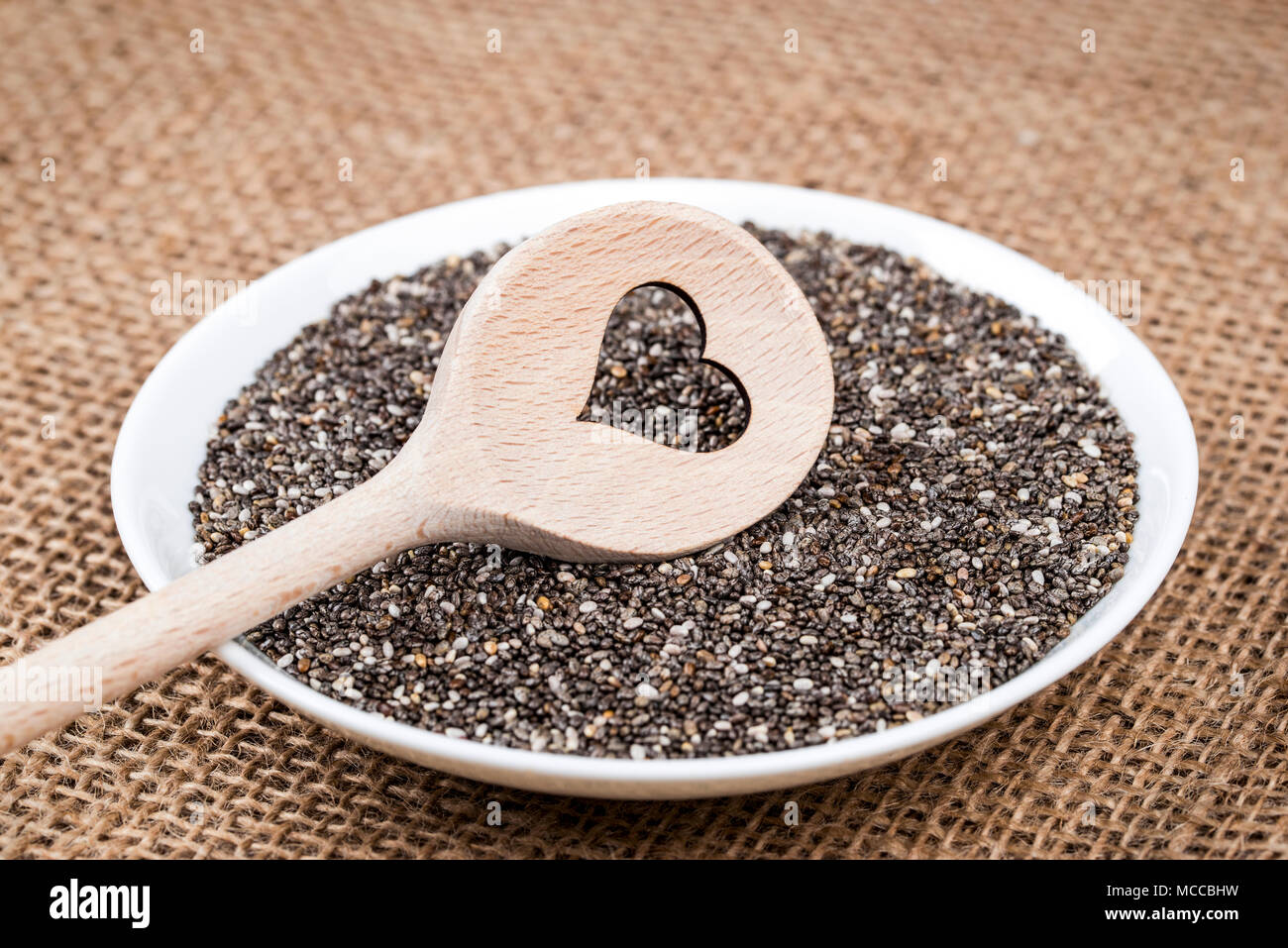 Chia seeds on white porcelain plate with cooking wooden spoon (cut ...