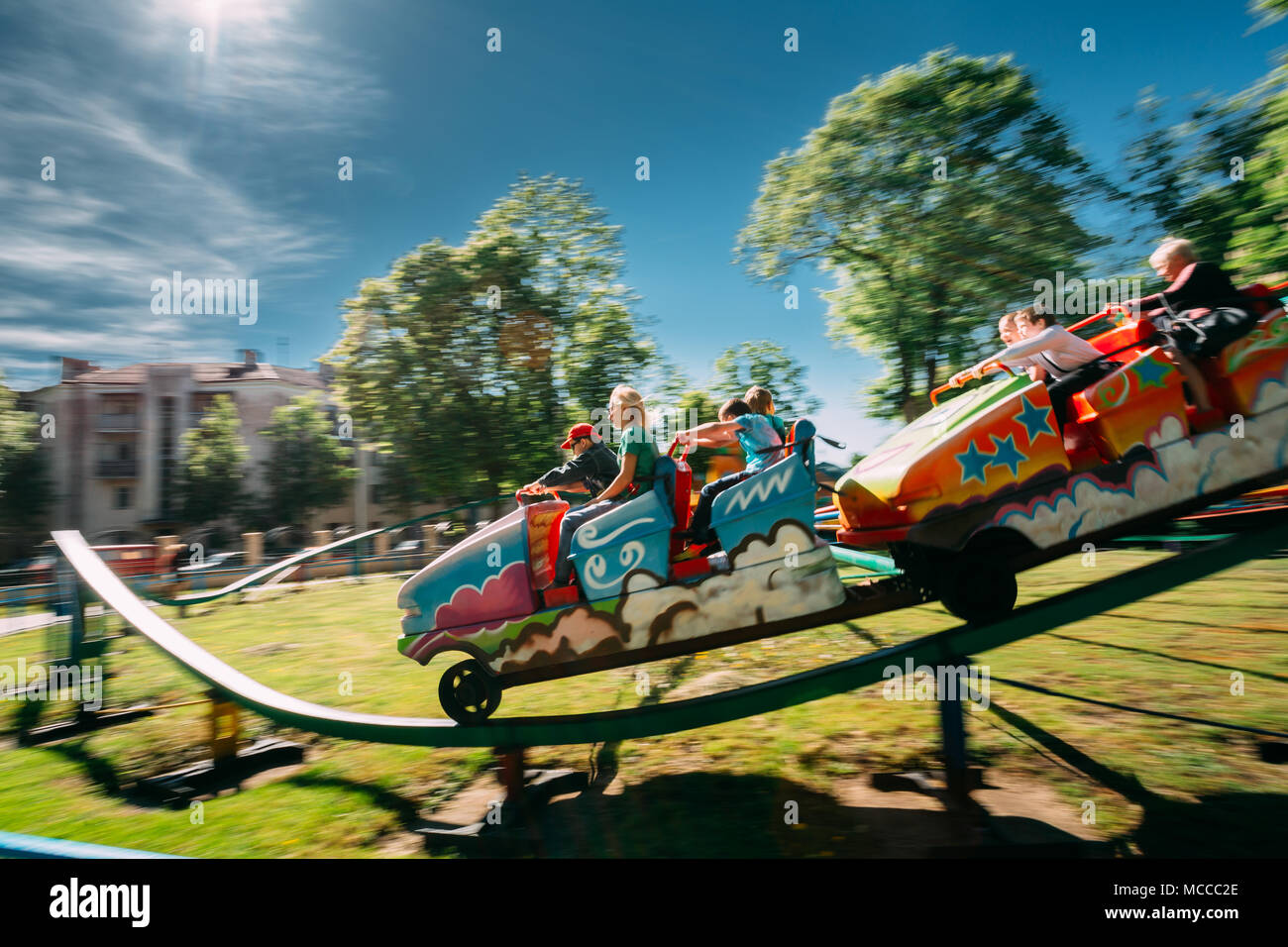 People Having Fun On Rollercoaster In Park. Photo With Zoom Blur For ...