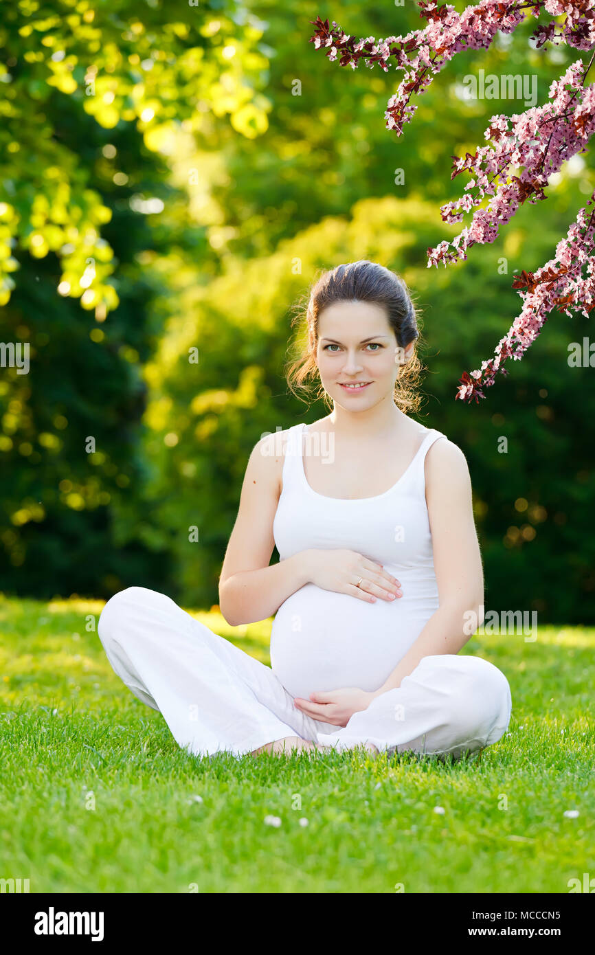 Beautiful pregnant woman in the spring park Stock Photo - Alamy
