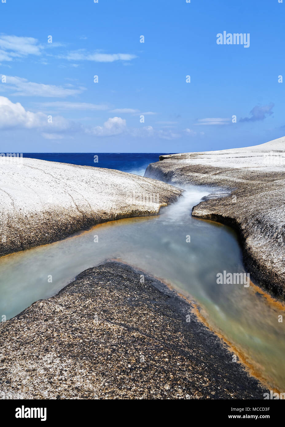 On a beach of white pumice stone flows from two ditches together in the ...