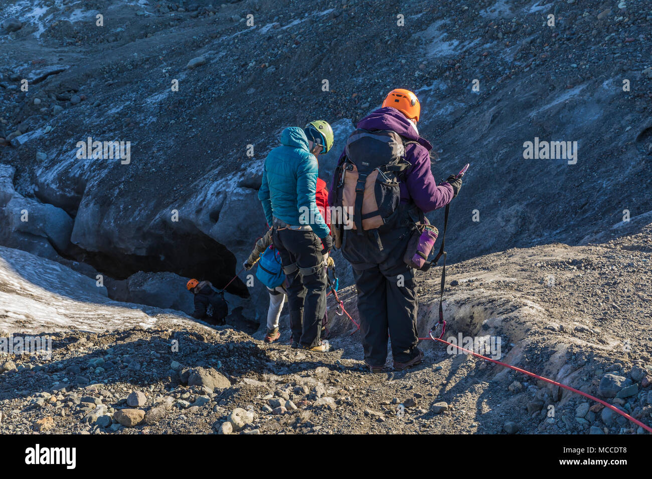 Group entering ice cave in Svinafellsjökull, a valley glacier flowing ...