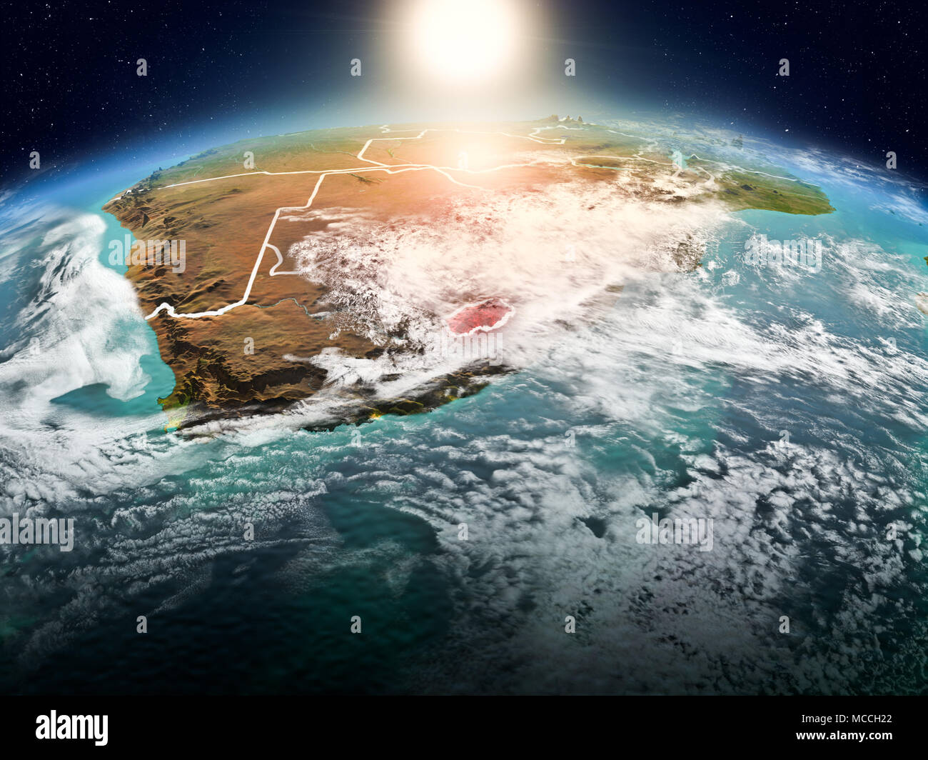 Sunrise above Lesotho highlighted in red on model of planet Earth in space with visible country ...