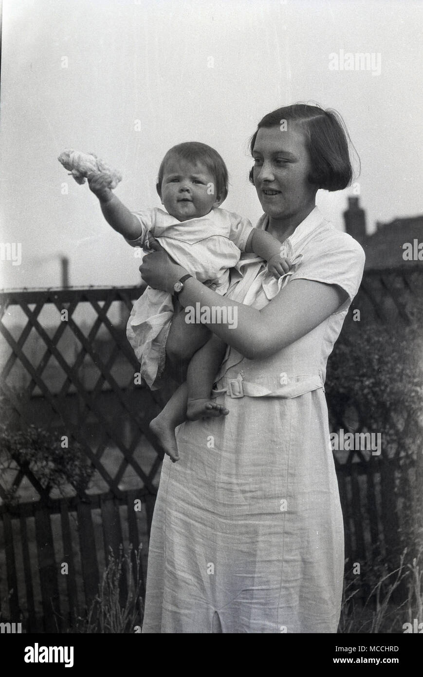 1940s, mother with her infant chlld at front gate Stock Photo - Alamy