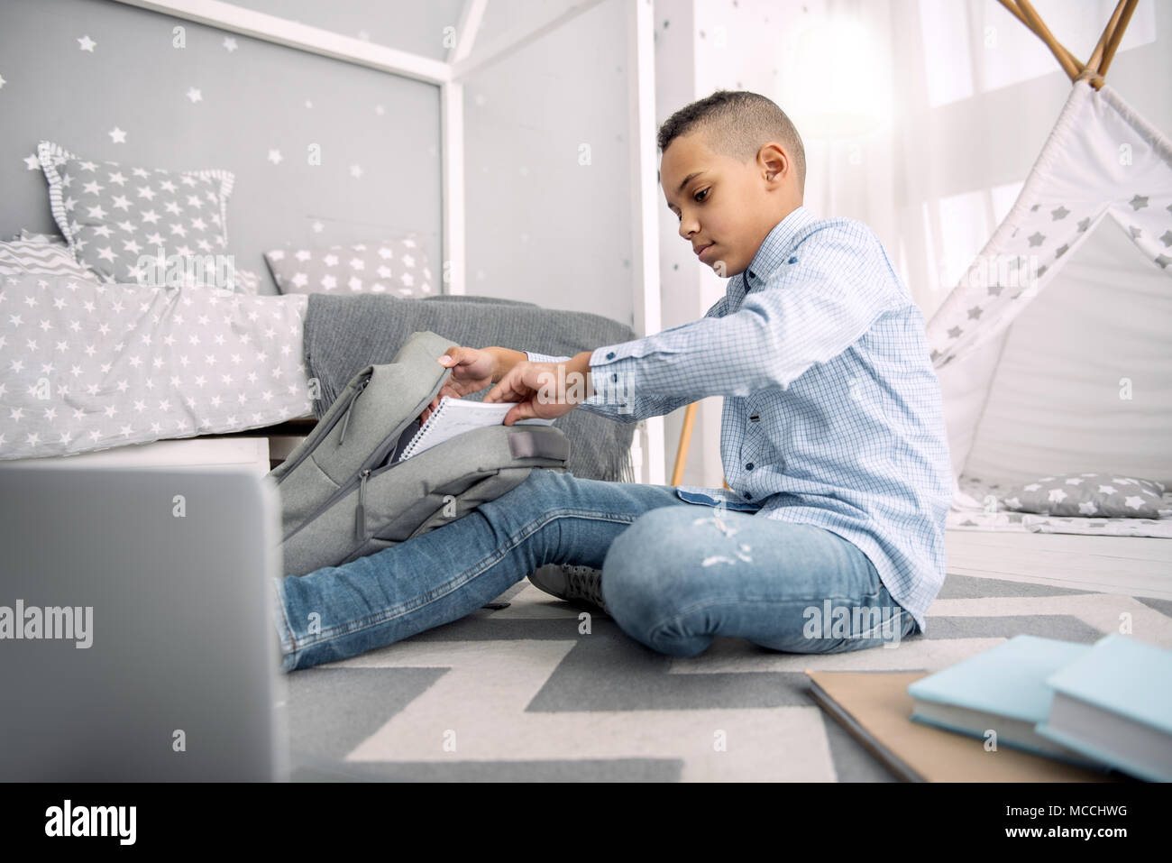 Concentrated young boy taking notebook Stock Photo - Alamy