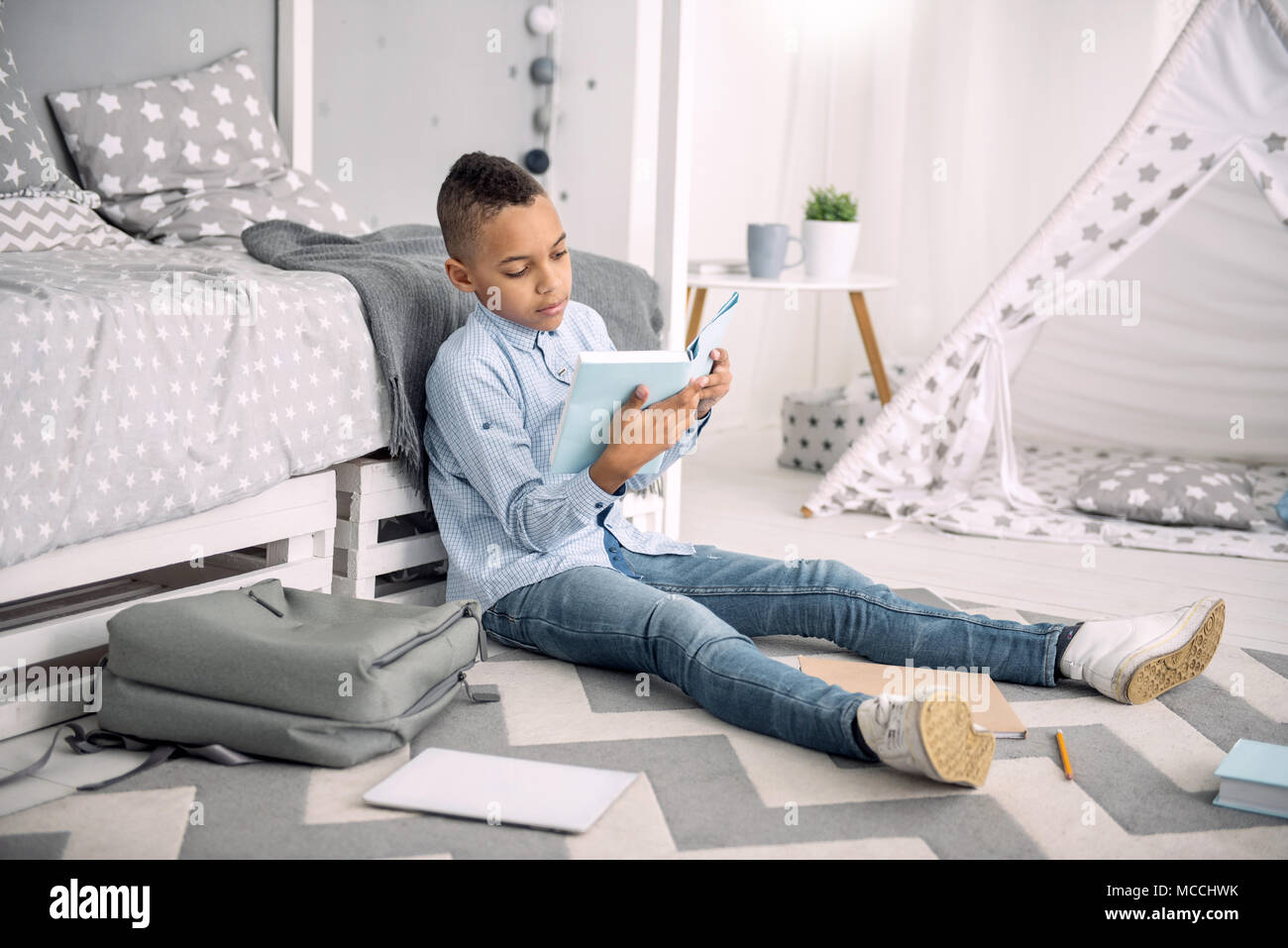 Smart ambitious boy reading book Stock Photo - Alamy