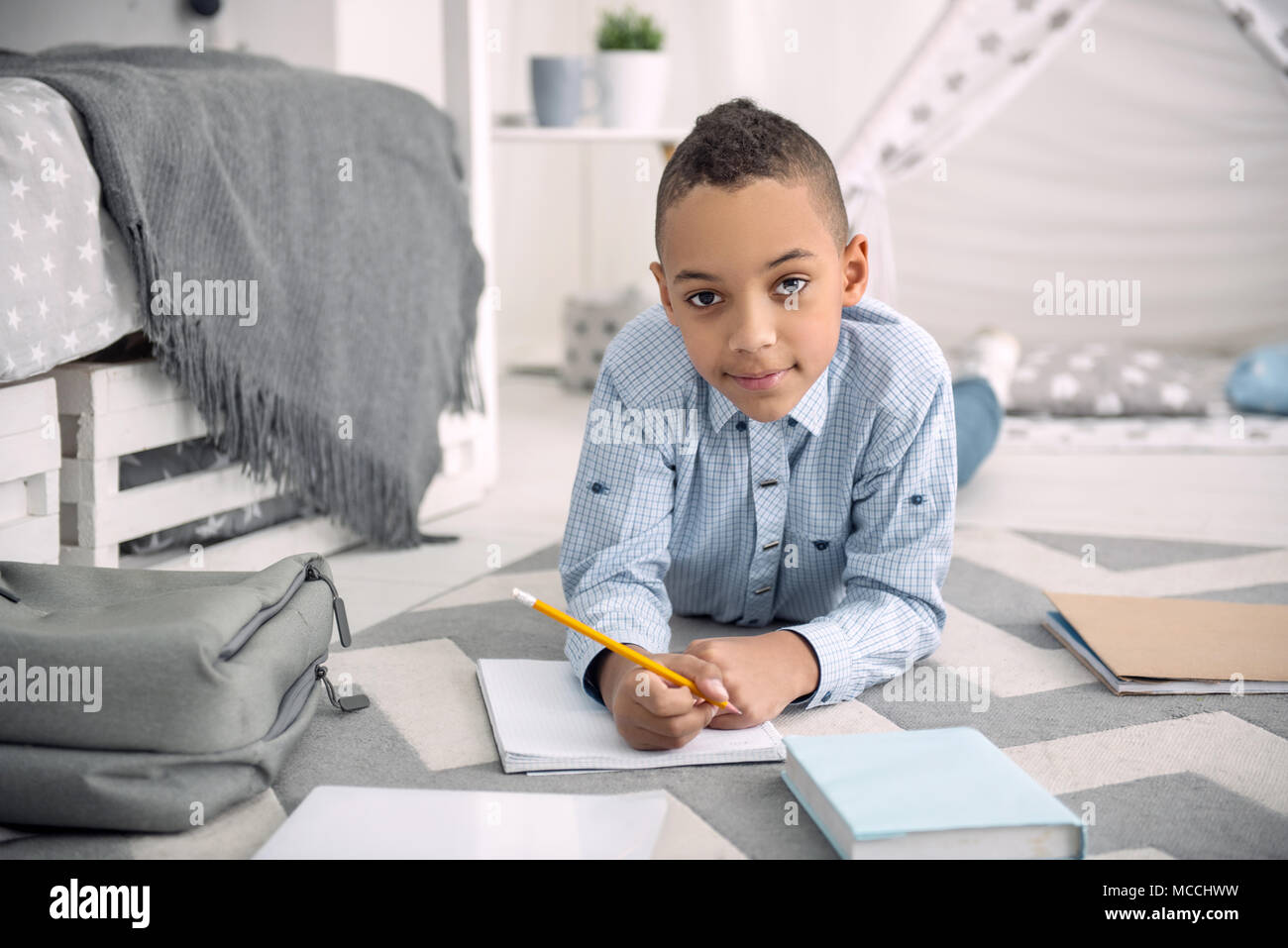 Satisfied smart boy performing homework Stock Photo - Alamy