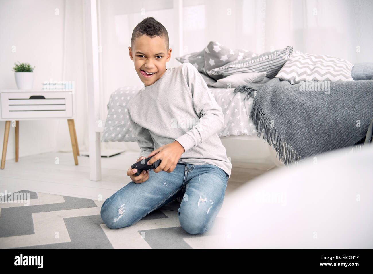 Vigorous ambitious boy playing video game Stock Photo - Alamy