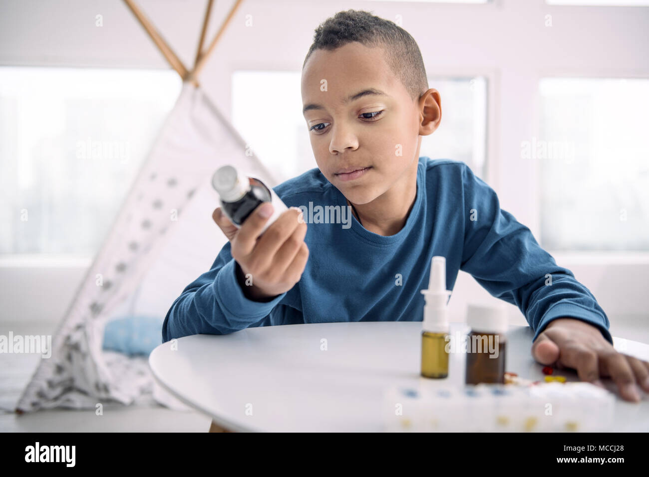 Smart nice boy taking medication Stock Photo - Alamy