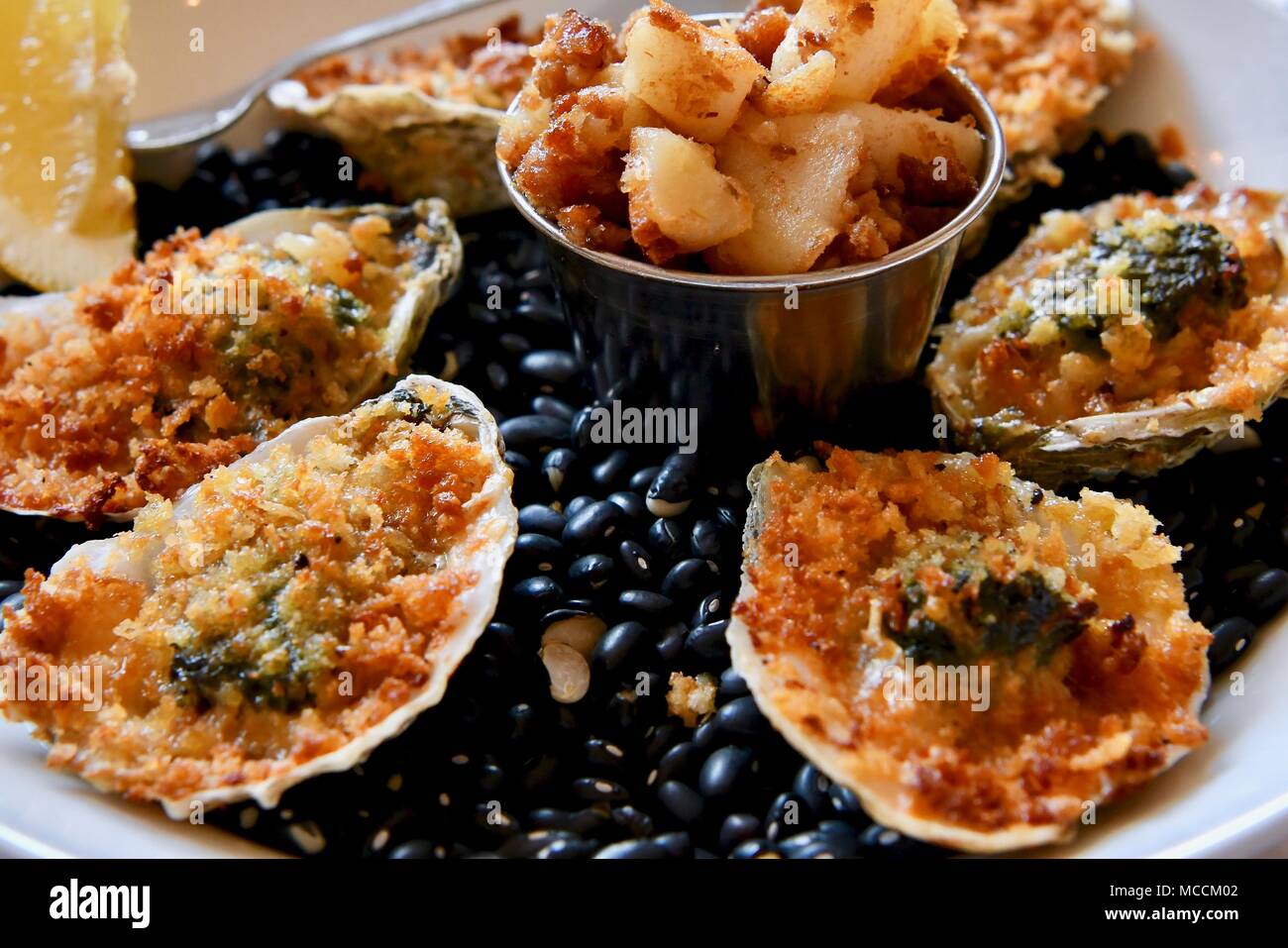 Oysters Rockefeller served over uncooked black beans and served with ...