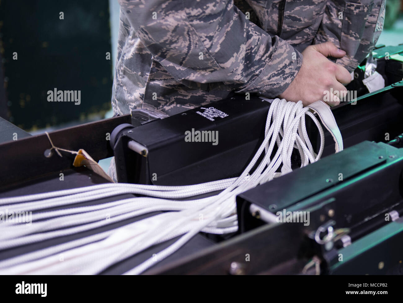 An Airman from aircrew flight equipment packs a parachute into an F-15 ...