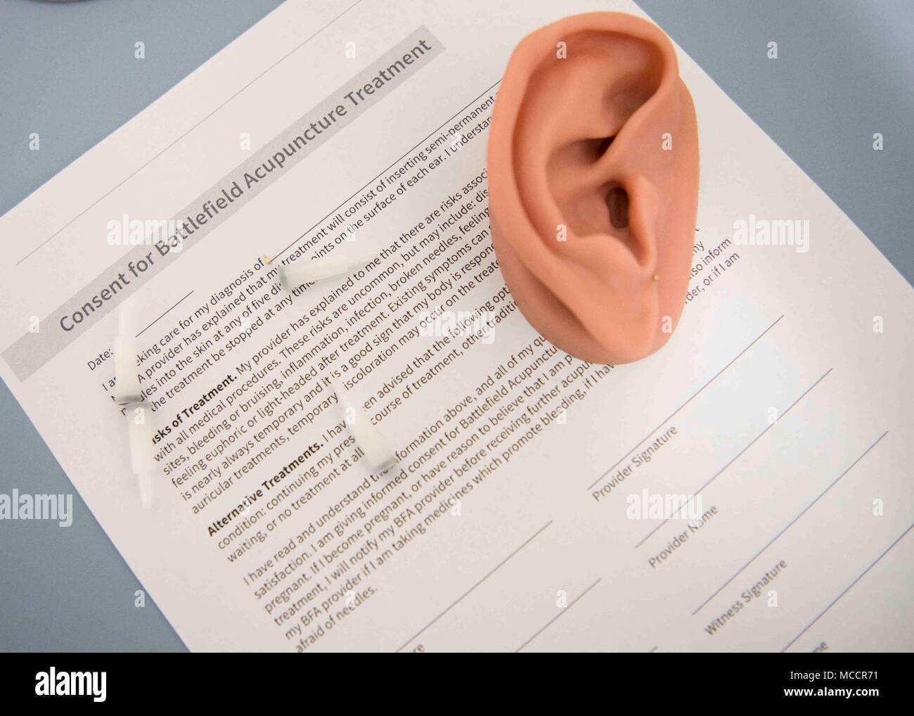 A release form and combat acupuncture dispensers and pins rest on ...