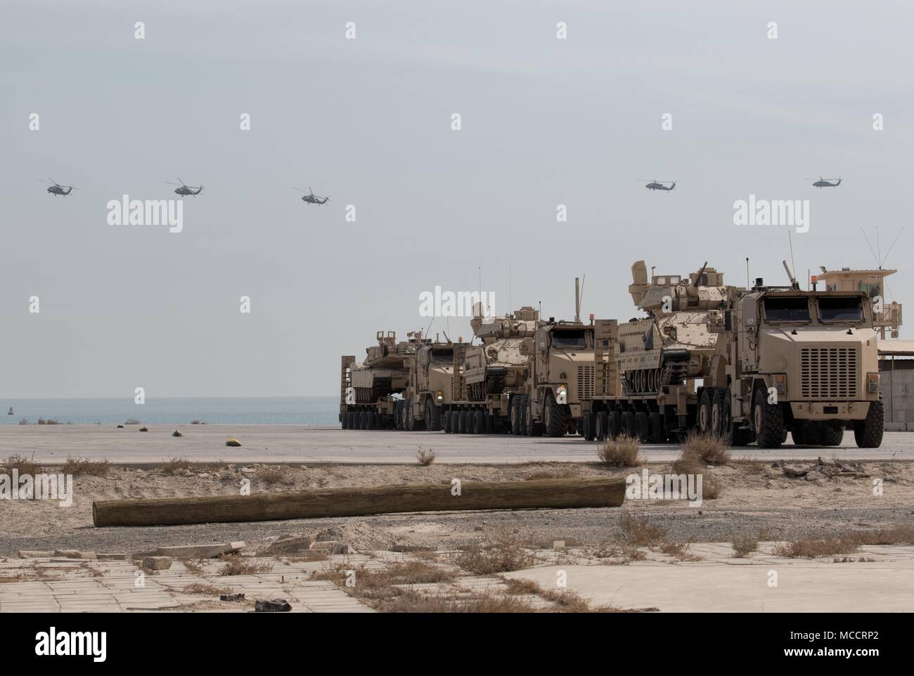 UH-60 Black Hawk helicopters fly over armored vehicles that have been ...