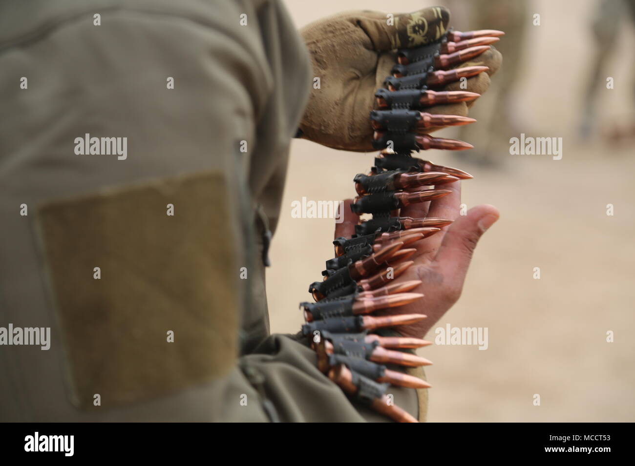 An Iraqi soldier prepares to load a belt of ammunition into a PKC ...