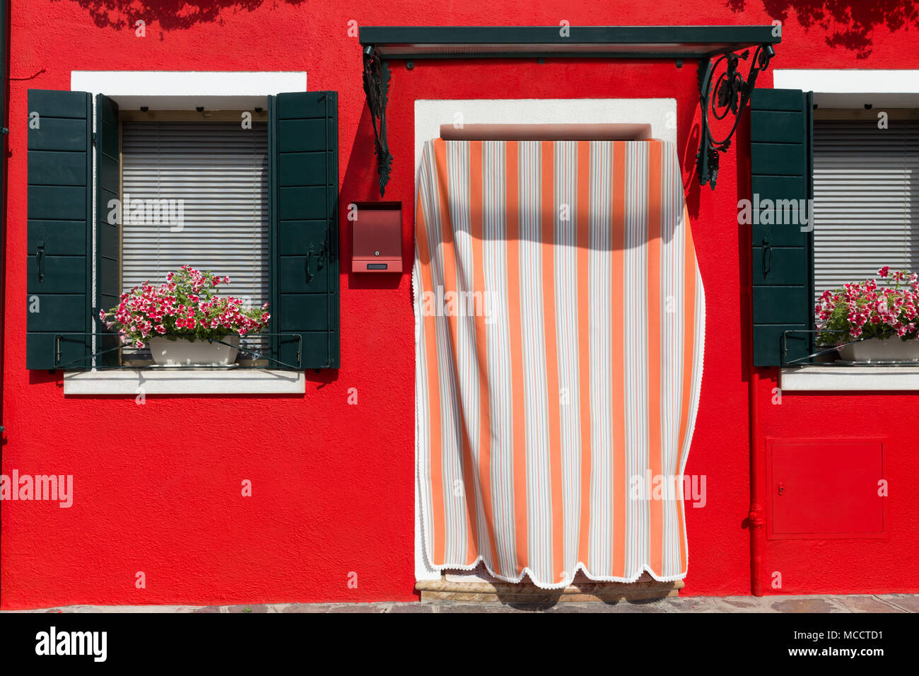 The facade of a red-painted house with beautiful Mediterranean-style ...