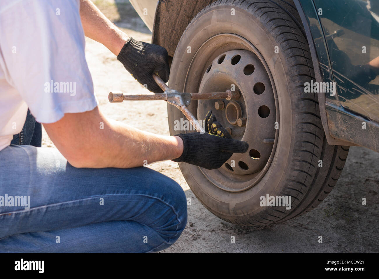 Mechanic changing wheel on car with a wrench Stock Photo - Alamy