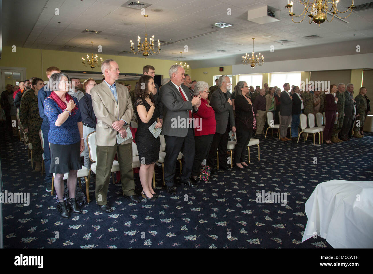 Guests stand for the national anthem during a retirement ceremony of U ...