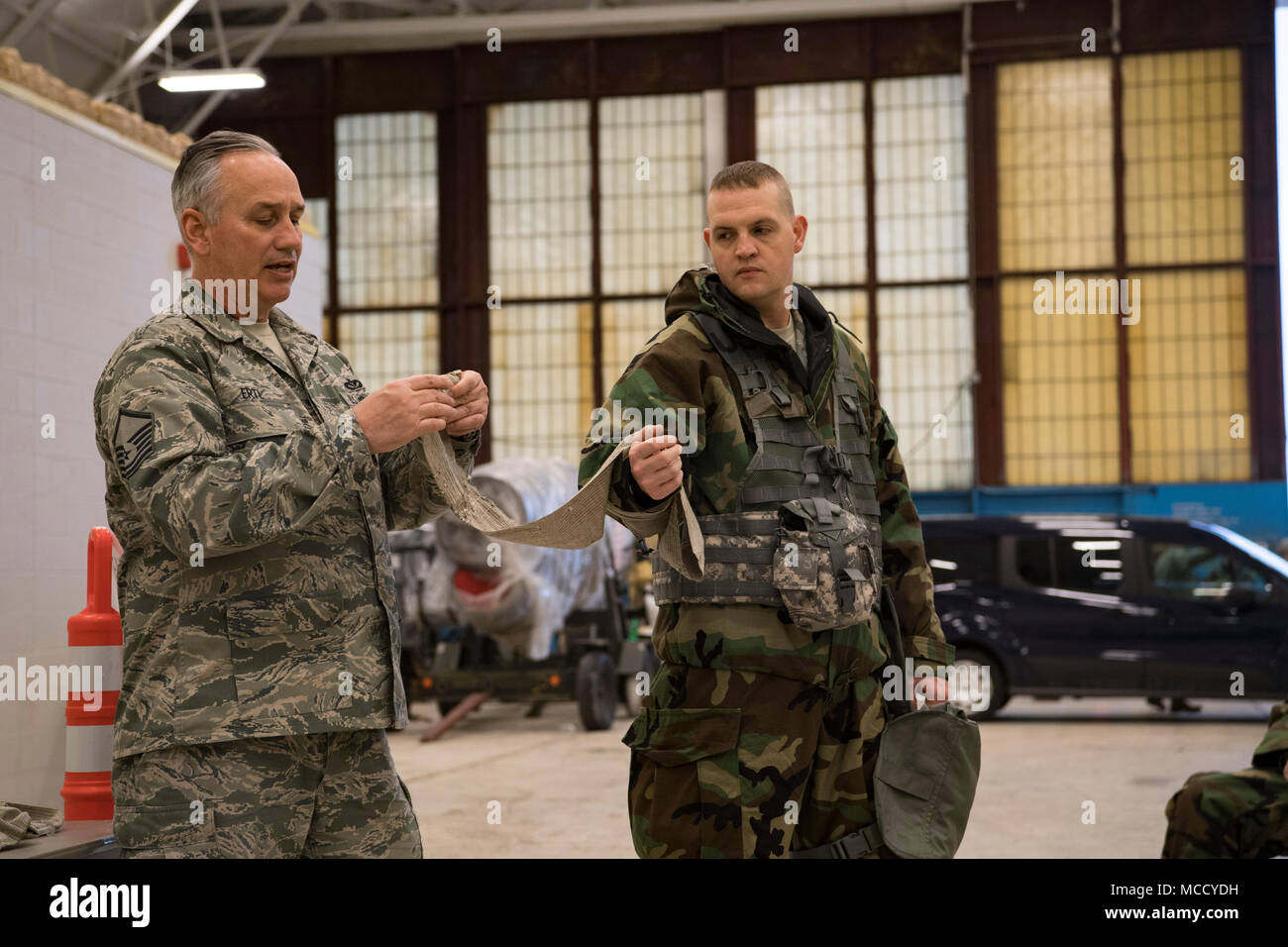 U.S. Air Force Master Sgt. Joe Ertl (left) demonstrates how to apply an ...